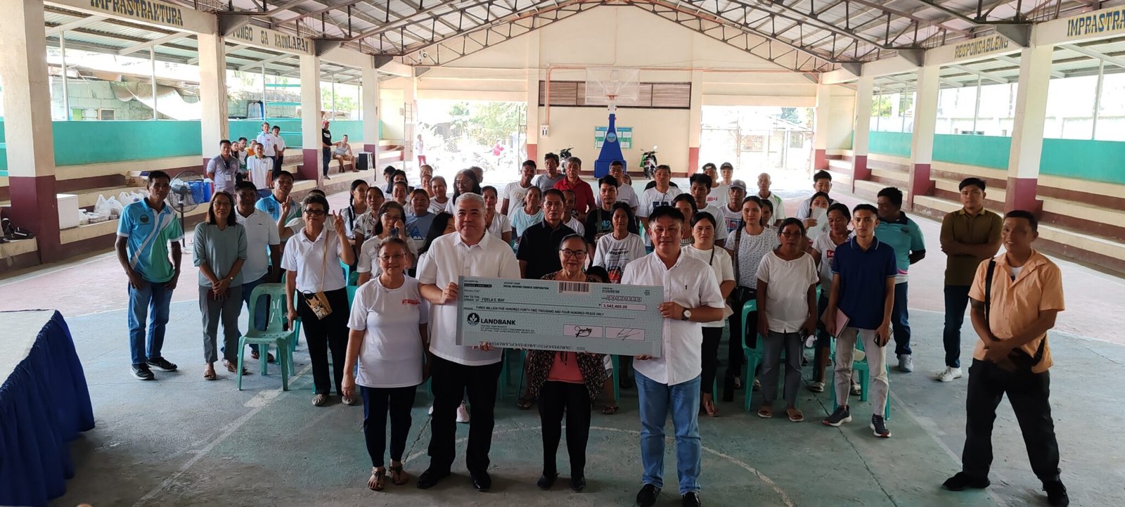 Government officials present housing assistance checks to beneficiaries ...